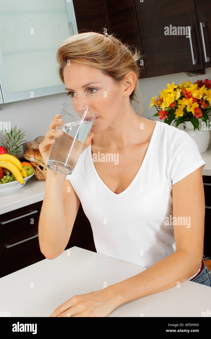 WOMAN IN KITCHEN DRINKING WATER Stock Photo - Alamy