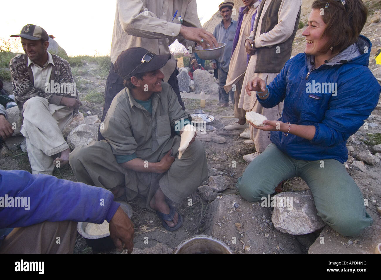A caucasian woman making chapati bread with some Balti men in Pakistan ...