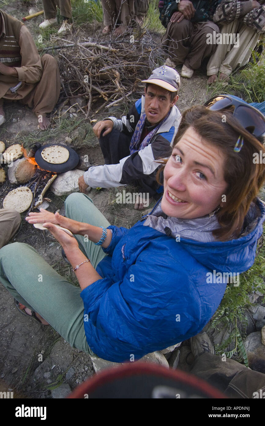 A caucasian woman making chapati bread with some Balti men in Pakistan ...