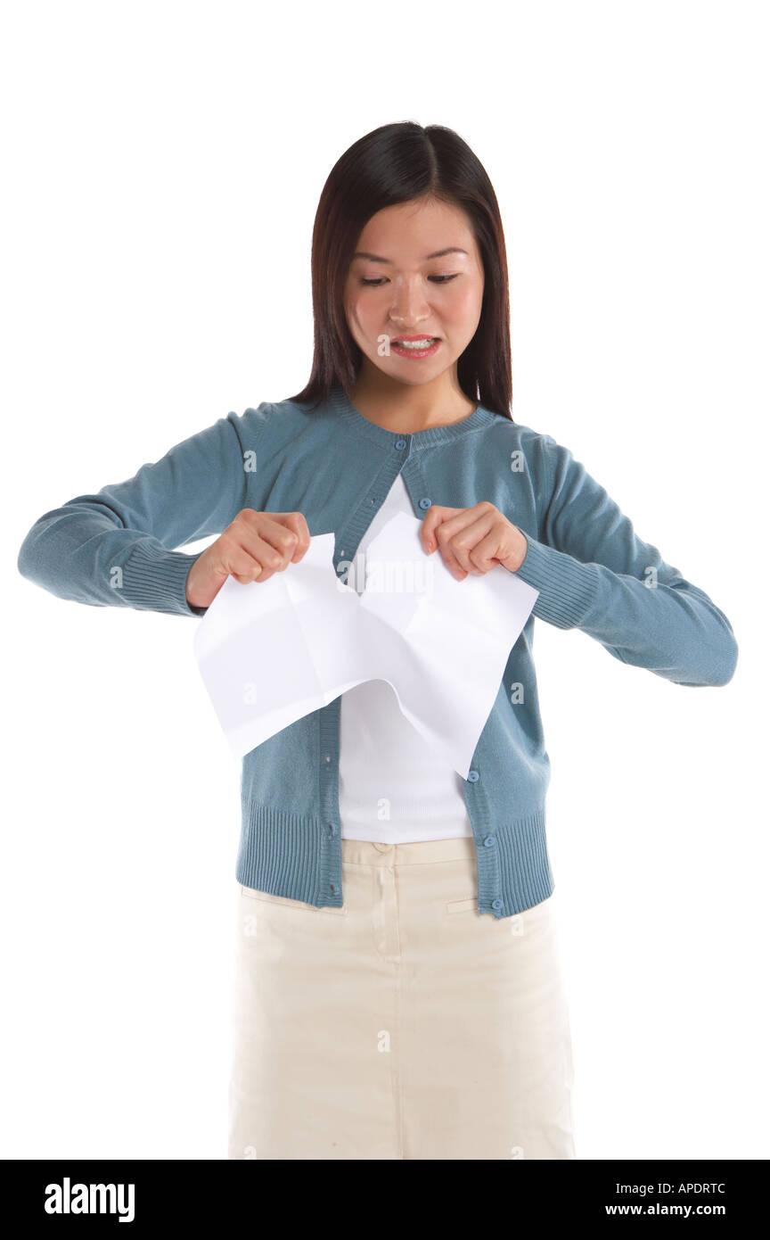 Young woman standing tearing paper angrily Stock Photo - Alamy
