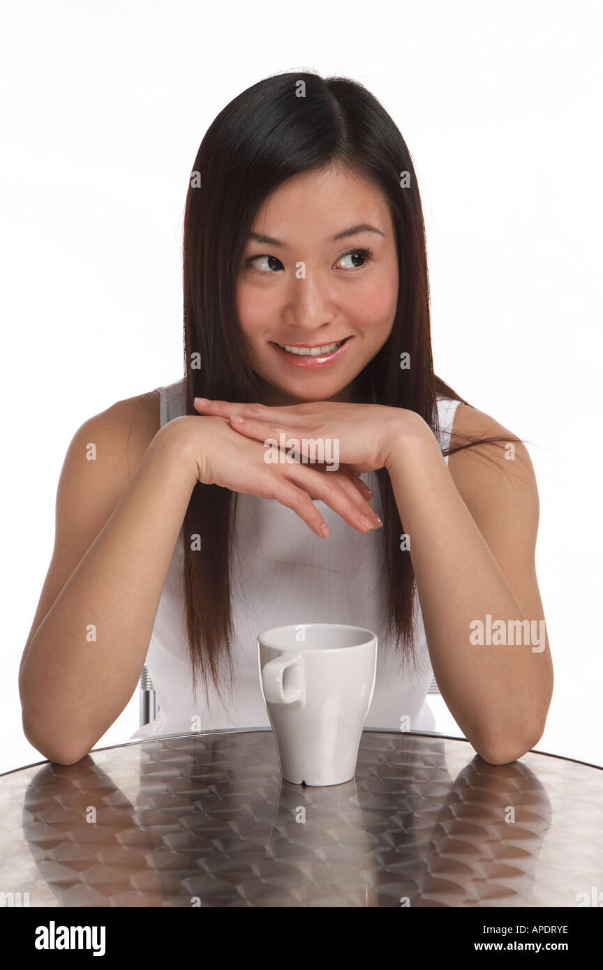 Young woman sitting with hands supporting chin Stock Photo - Alamy