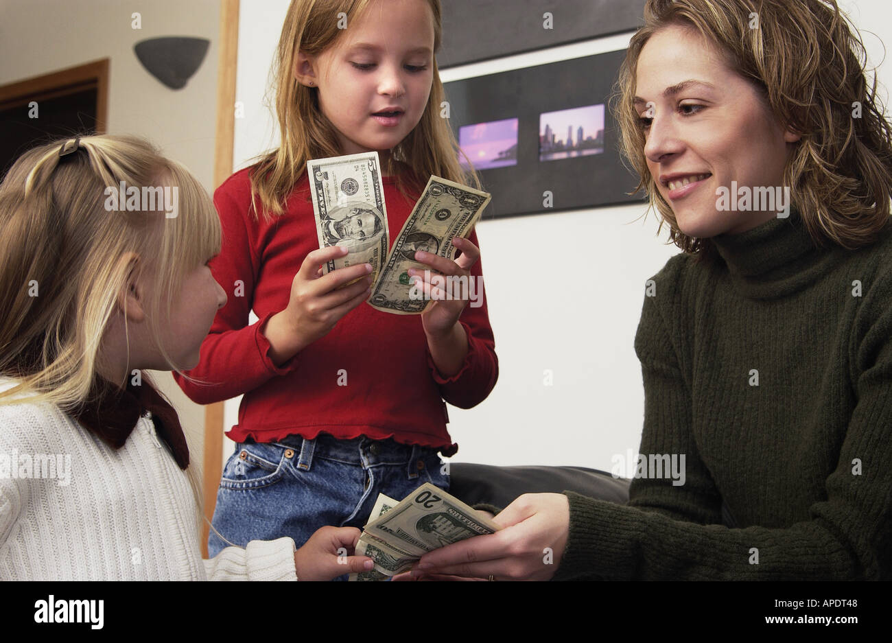 Mom giving daughters allowance Stock Photo - Alamy