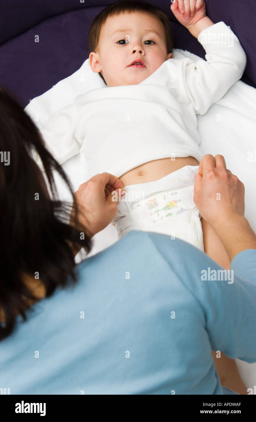 Woman changing baby boy s diaper Stock Photo - Alamy
