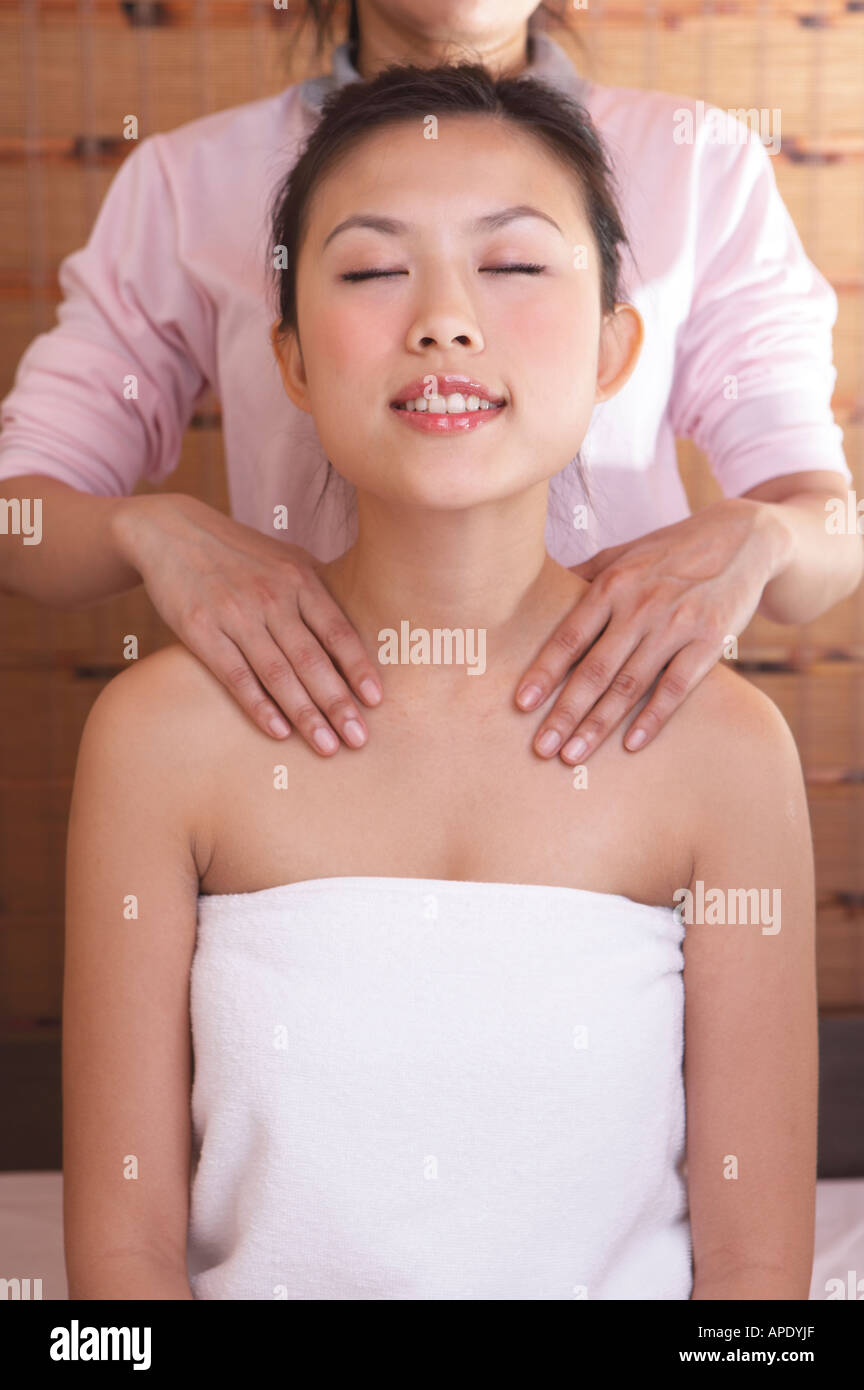 Young woman getting massage on shoulders front view Stock Photo - Alamy