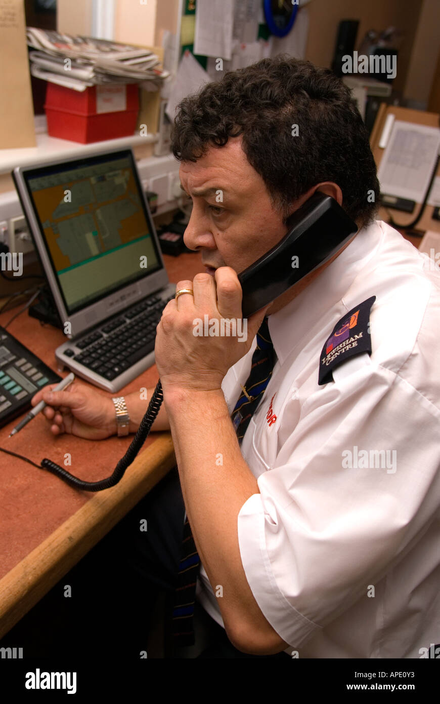 Security guard on duty in CCTV control room talking on telephone ...