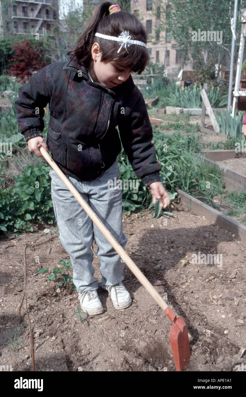 An Hispanic child turns over soil in a plot in a Lower East Side ...
