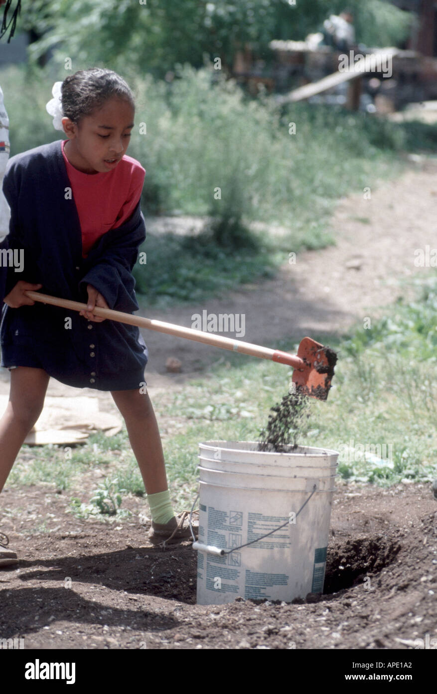 An Hispanic child turns over soil in a plot in a Lower East Side ...