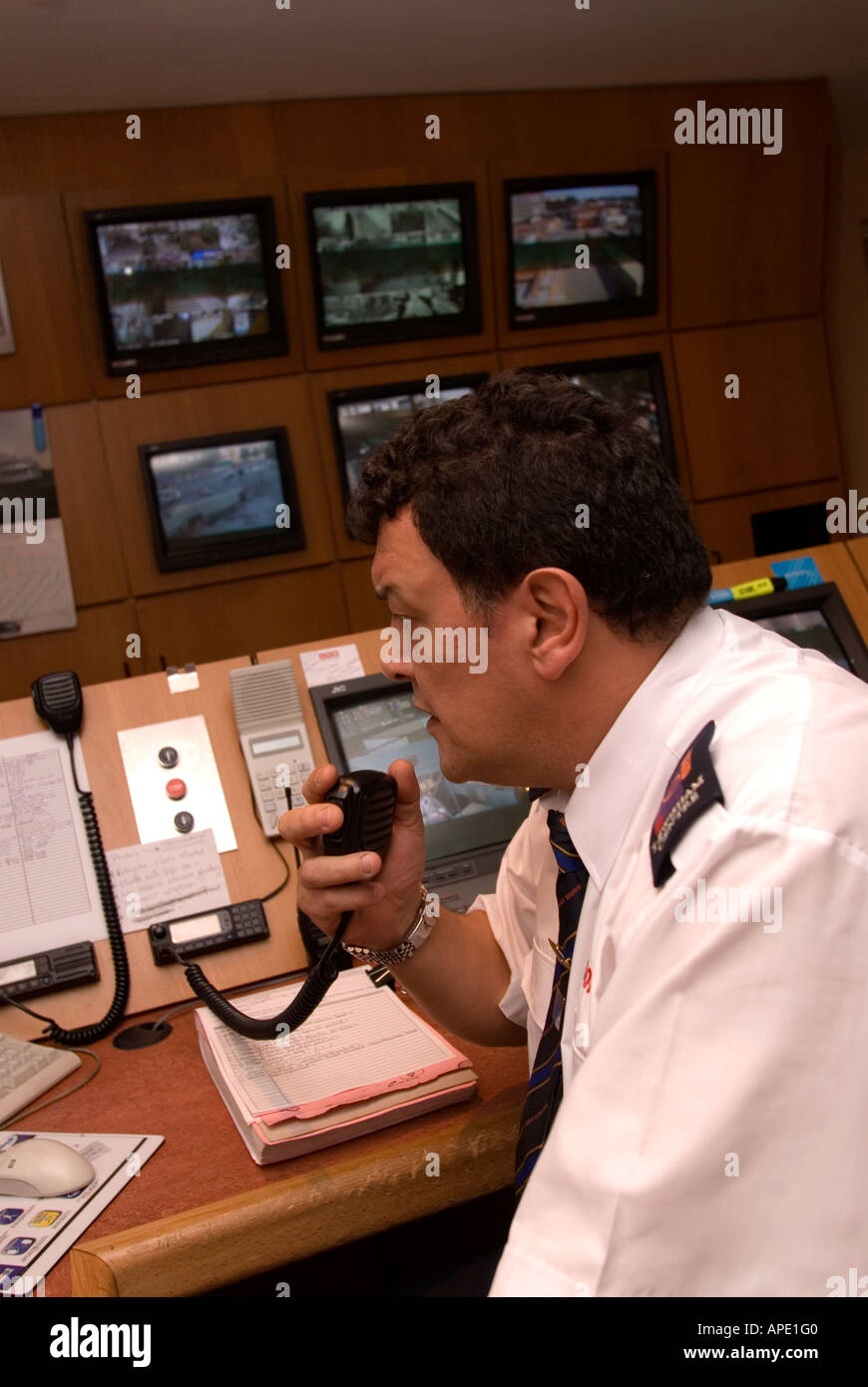 Security guard on duty in CCTV control room talking on radio, Lewisham ...