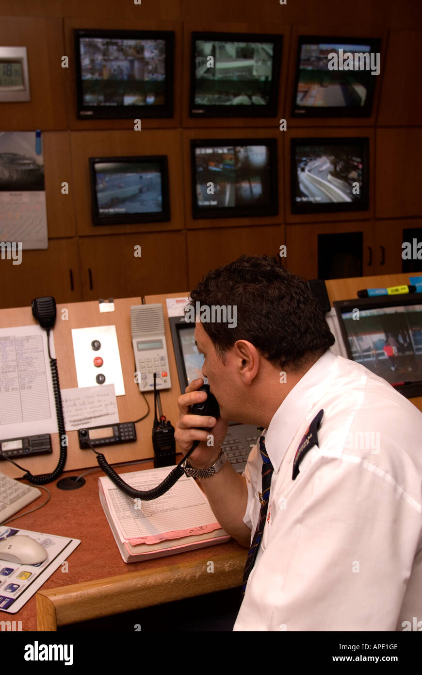 Security guard on duty in CCTV control room talking on radio, Lewisham ...