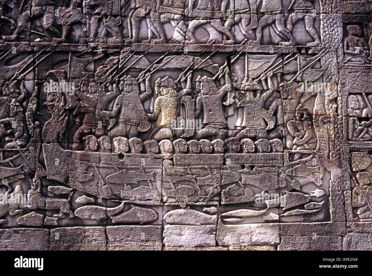Bas relief carving of a ship full of soldiers and fish in the sea at ...