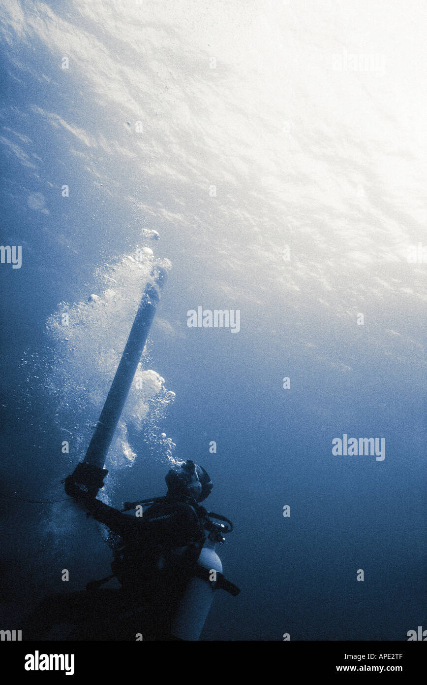 Scuba diver releasing inflatable surface marker safety sausage to ...