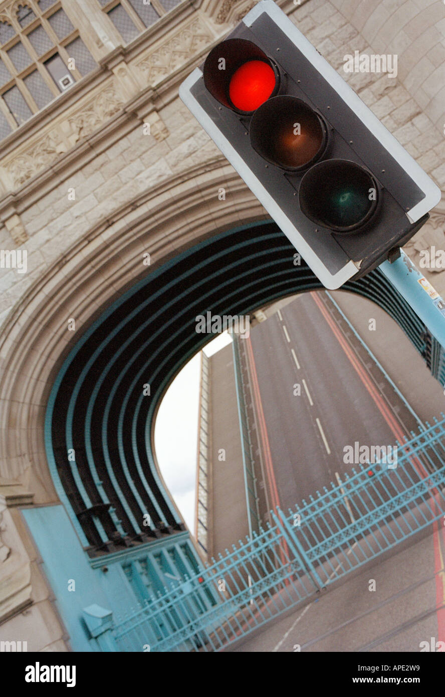 Traffic light on red and gates closed at entrance to tower bridge ...