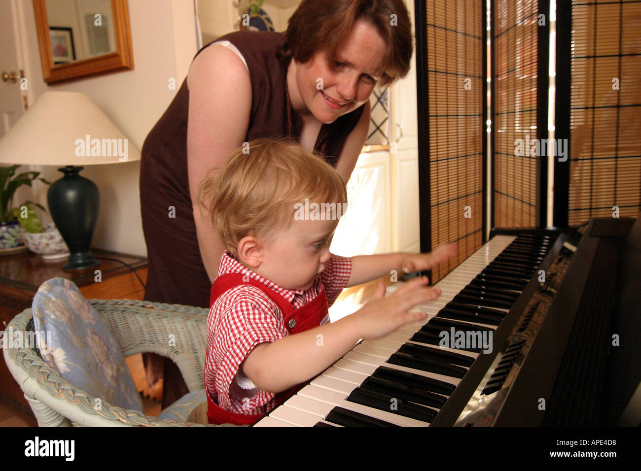 boy aged two being supervised on the keyboard by woman Stock Photo - Alamy