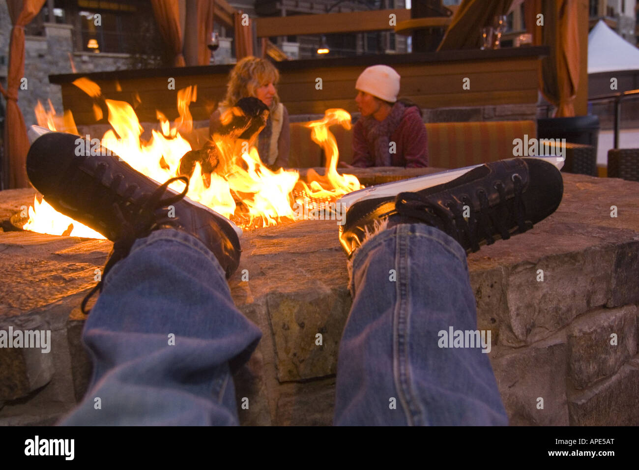 Looking past a childs ice skates at a fire and two women Stock Photo ...