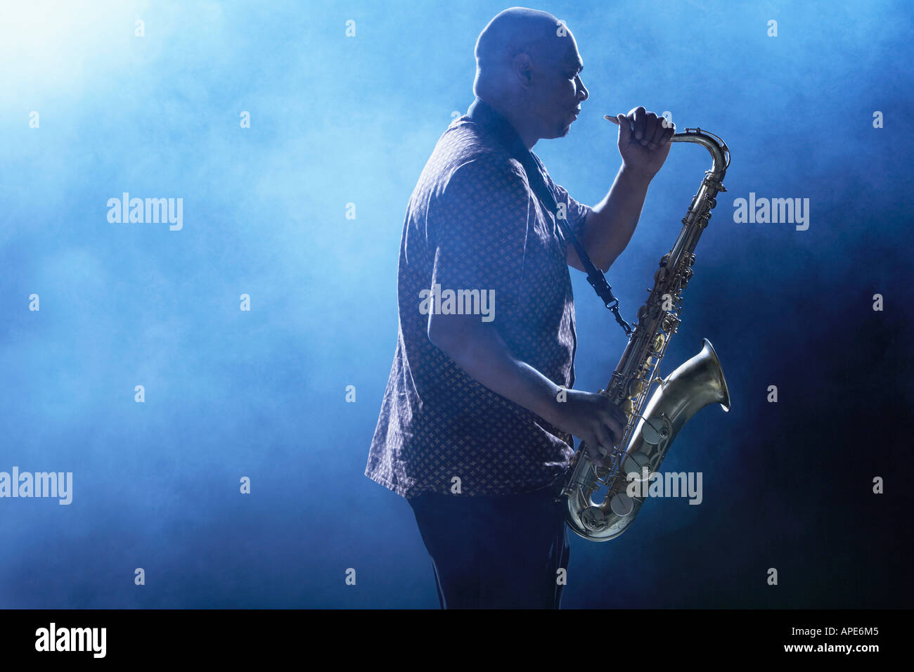 Man Playing Saxophone in smoky place, side view Stock Photo - Alamy