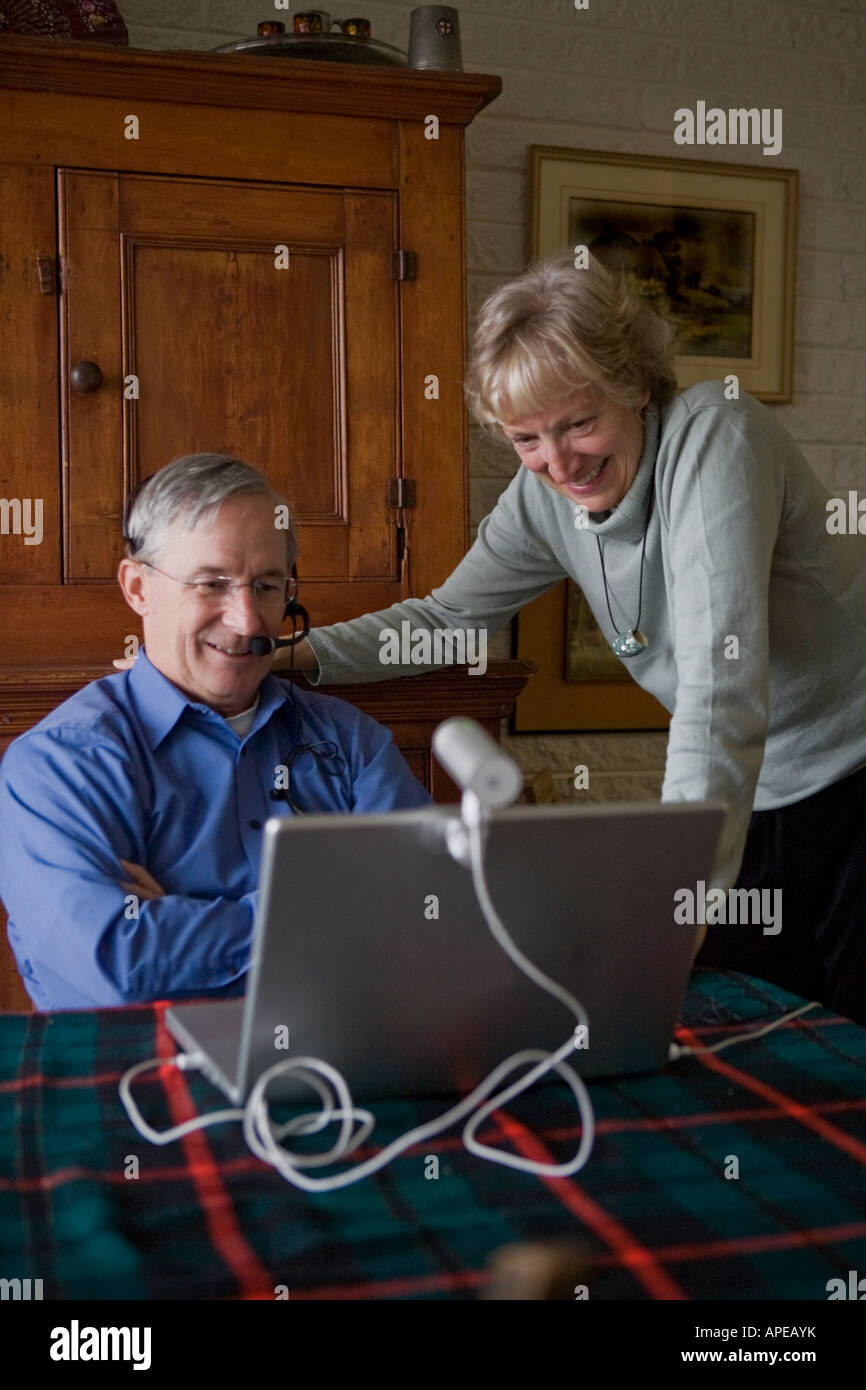 A man talks on the telephone over a computer Stock Photo - Alamy