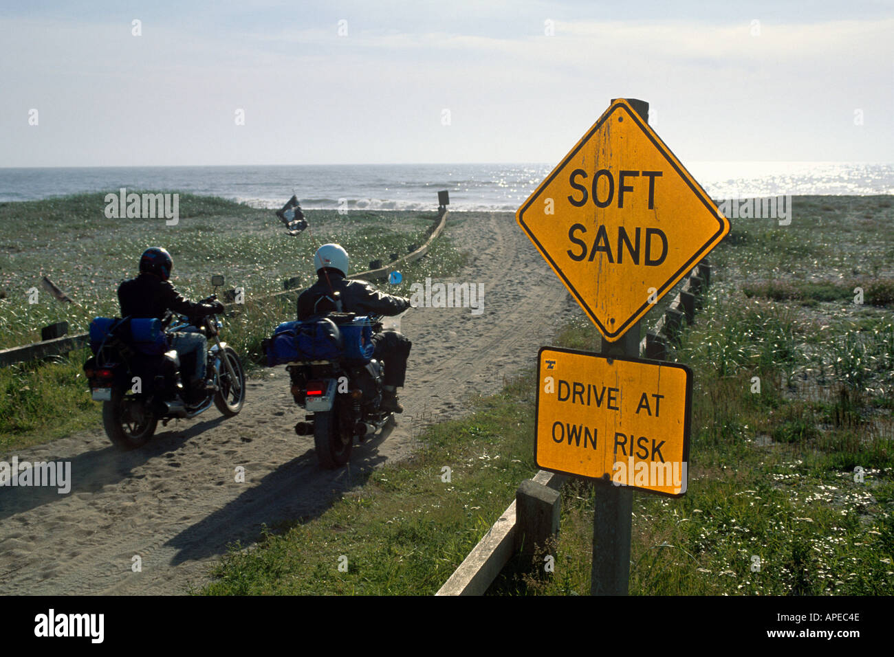 Soft sand warning sign and motorcyles riding onto beach Redwood ...
