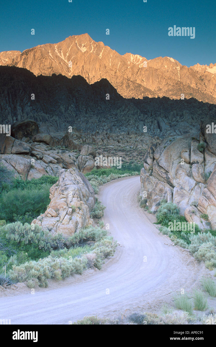 Twisting curves on rural dirt road below mountain peak Movie Road ...