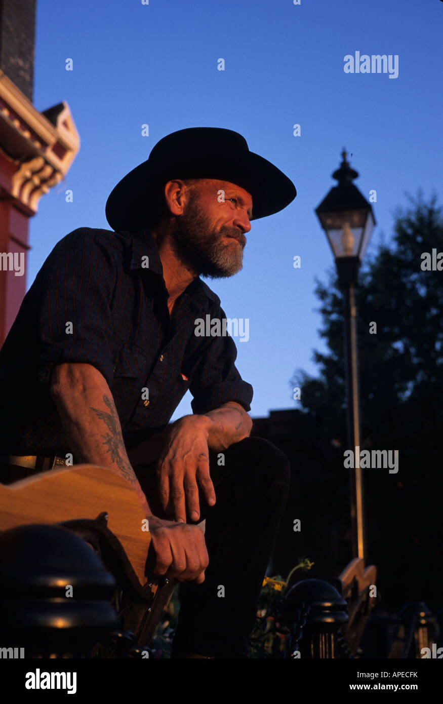 A cowboy stands looking at the sunset in a western town Stock Photo - Alamy