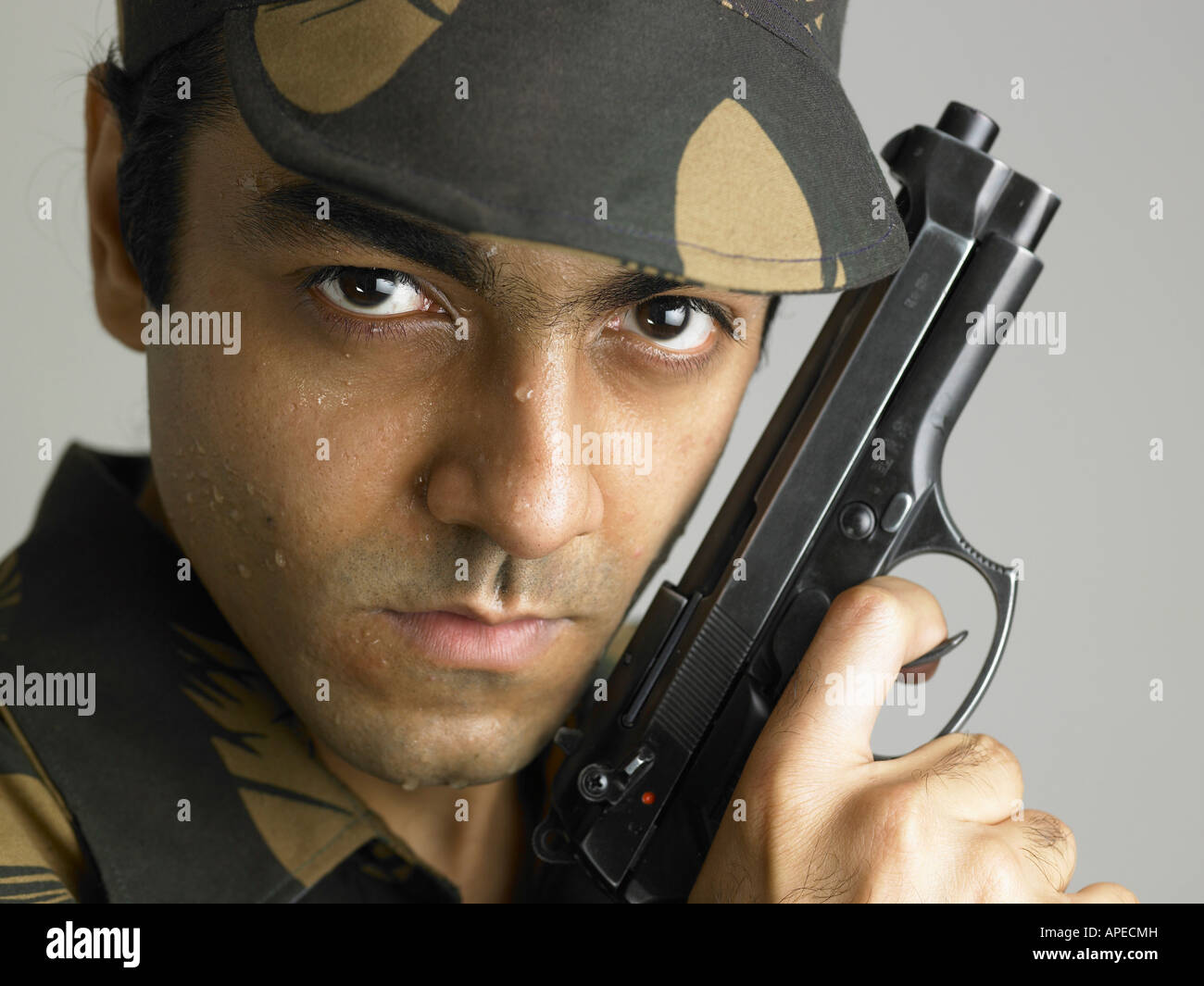 Indian army soldier in angry expression holding handgun Stock Photo - Alamy