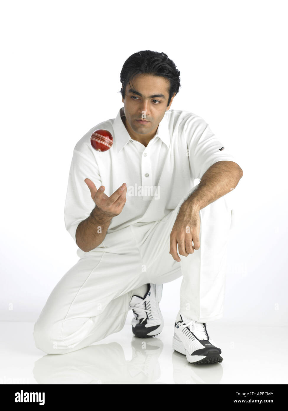 Indian bowler sitting on knee and throwing ball Stock Photo - Alamy
