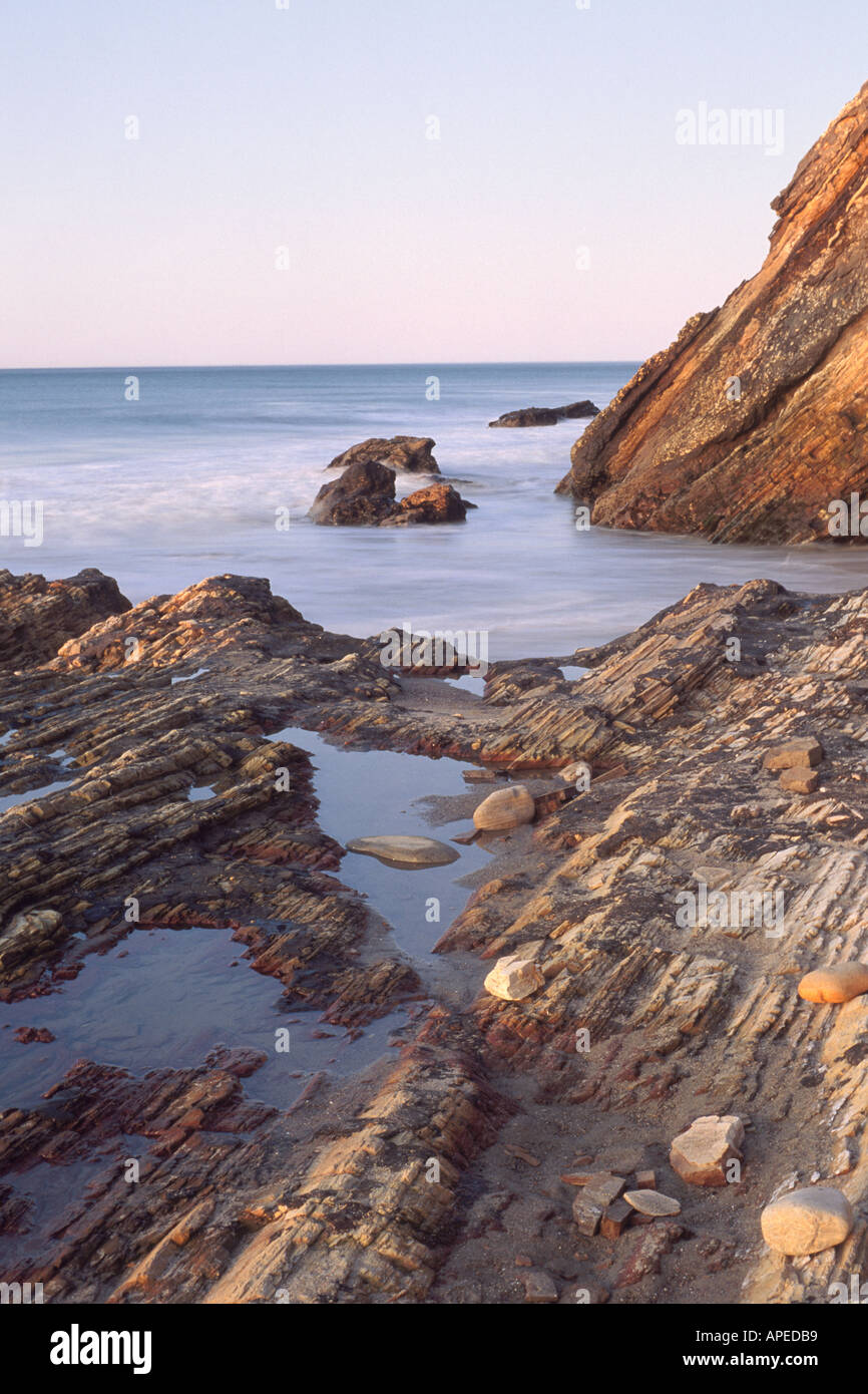 Ocean waves and striated rock layers below coastal cliff Garrapata ...