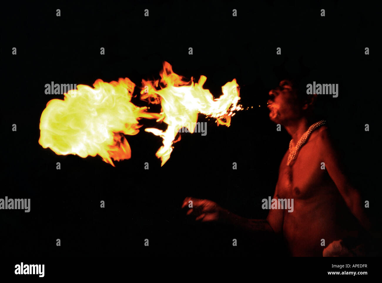 Man performing art of blowing fire out of his mouth Stock Photo - Alamy
