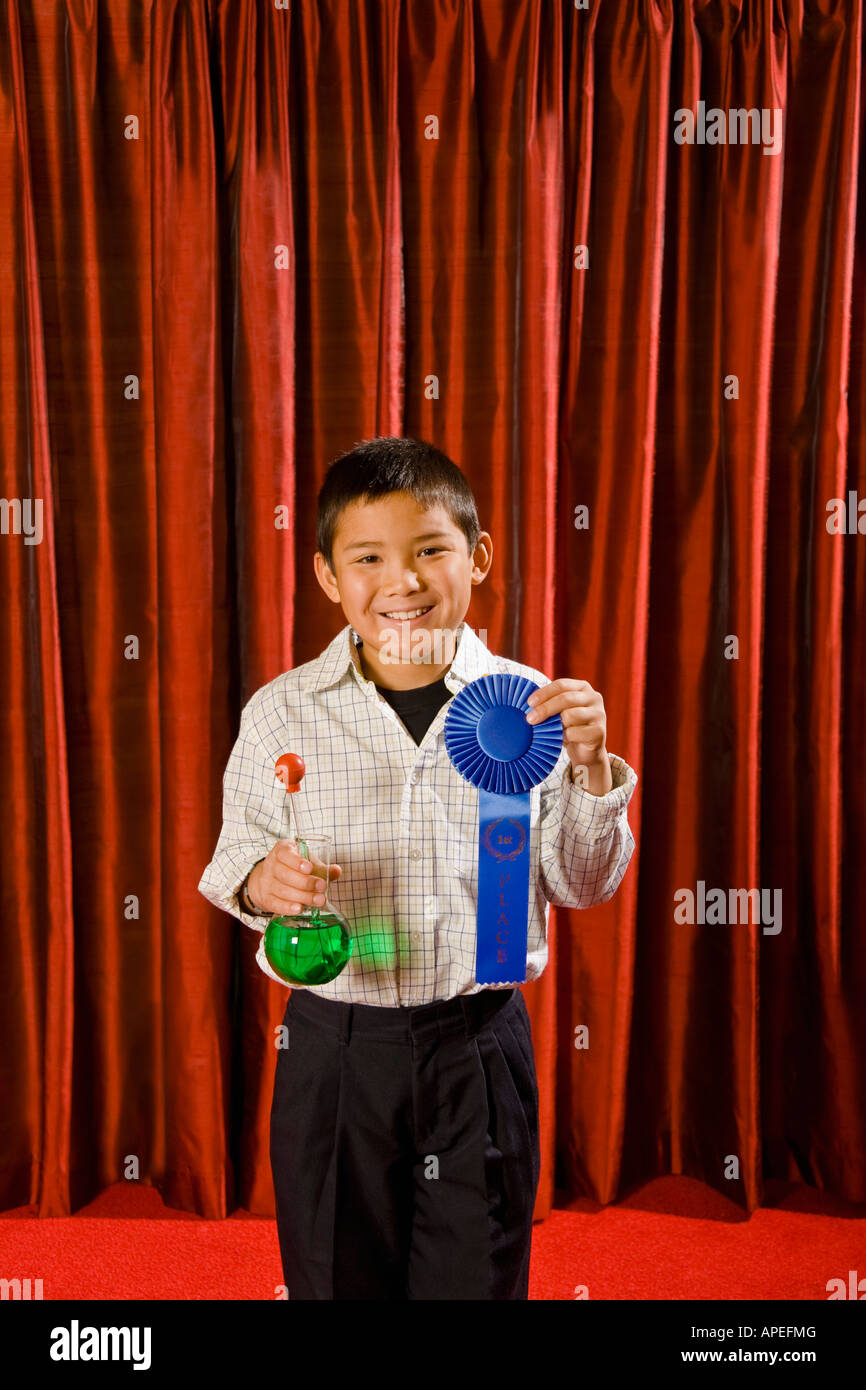 Asian boy holding prize ribbon on stage Stock Photo - Alamy