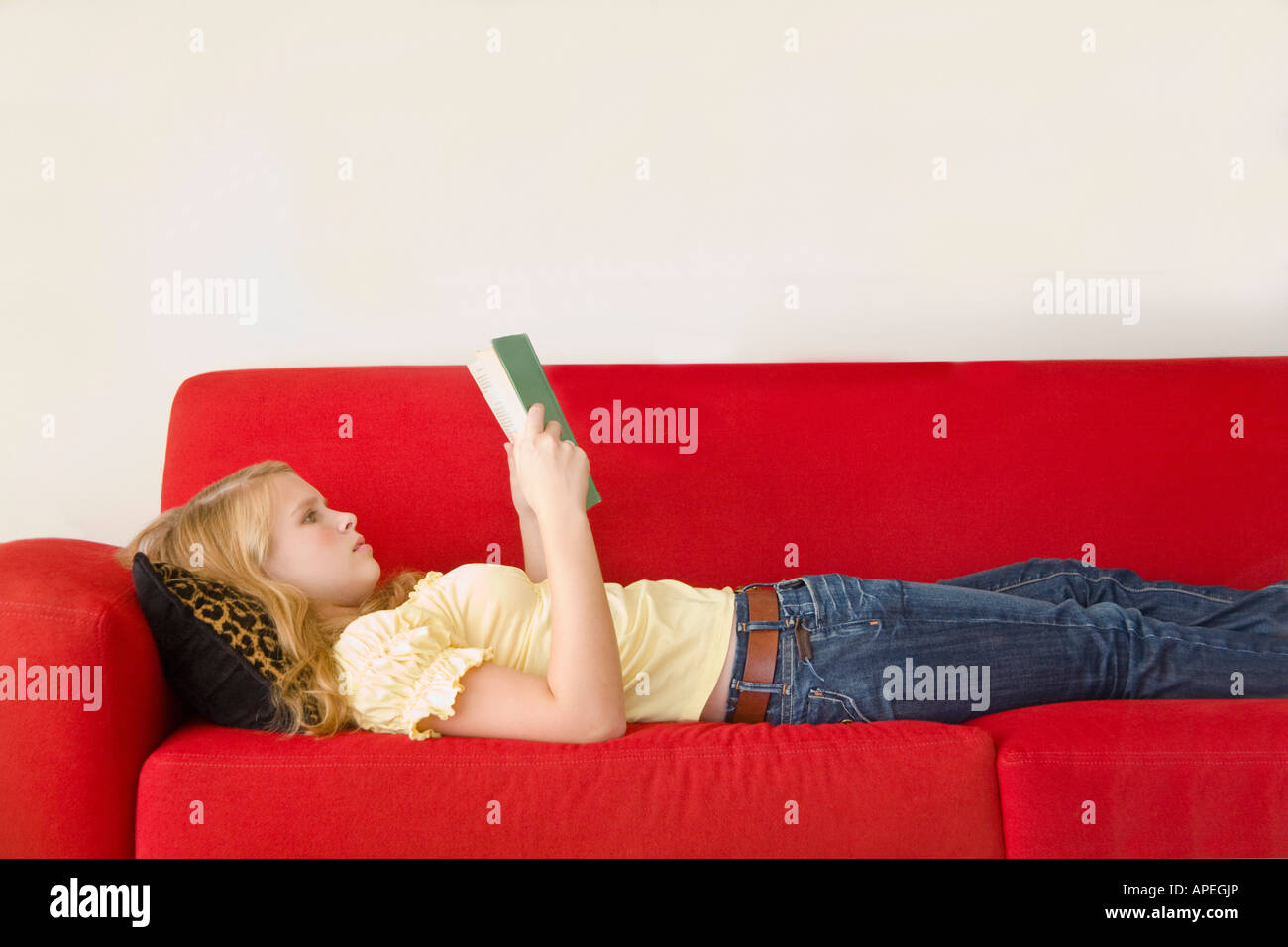 Teenage girl reading on sofa Stock Photo - Alamy