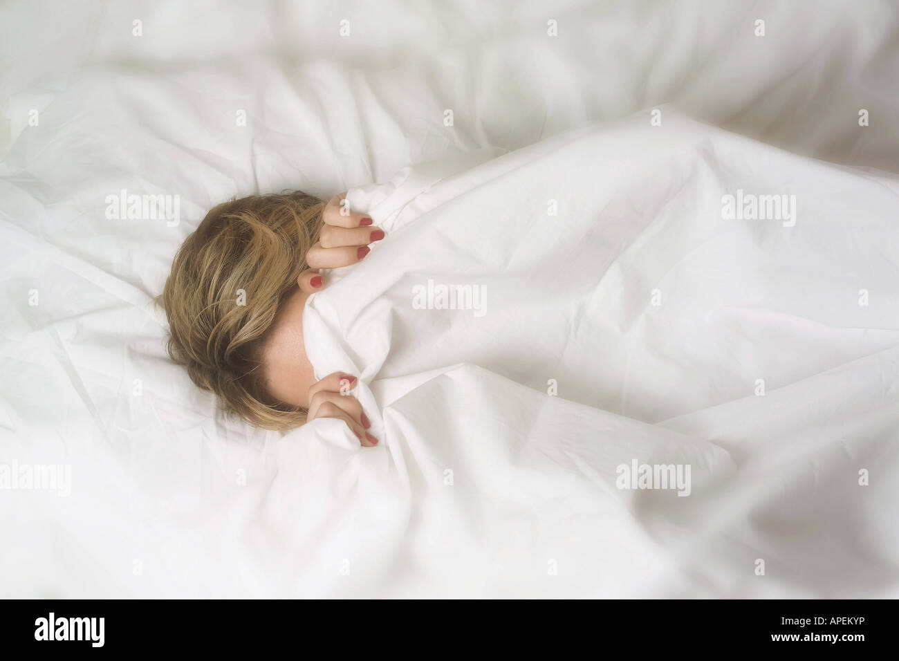 Woman in bed hiding her face Stock Photo - Alamy