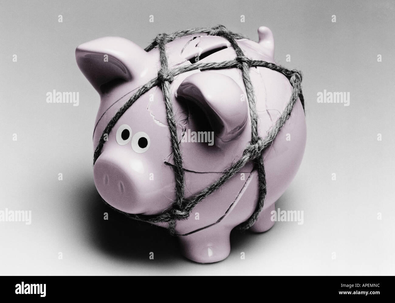 Broken piggy bank reassembled with twine Stock Photo - Alamy
