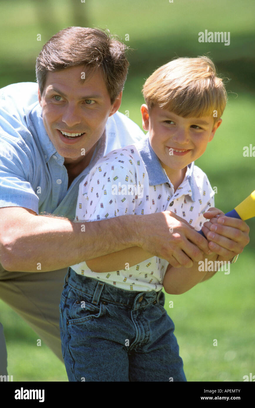 Father guiding son to use baseball bat Stock Photo - Alamy