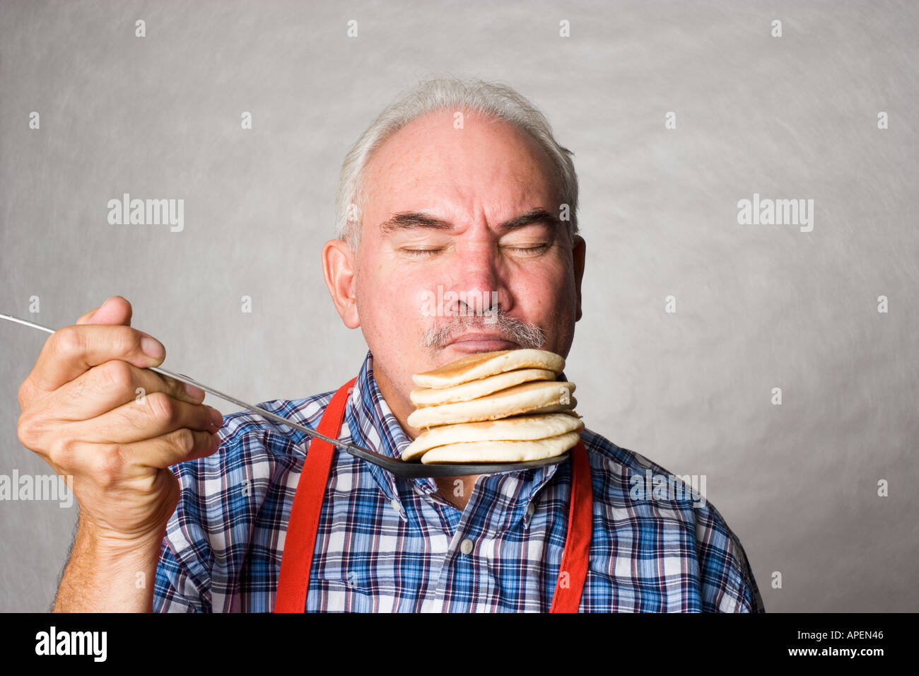 Portrait senior Latino man making pancakes Stock Photo - Alamy