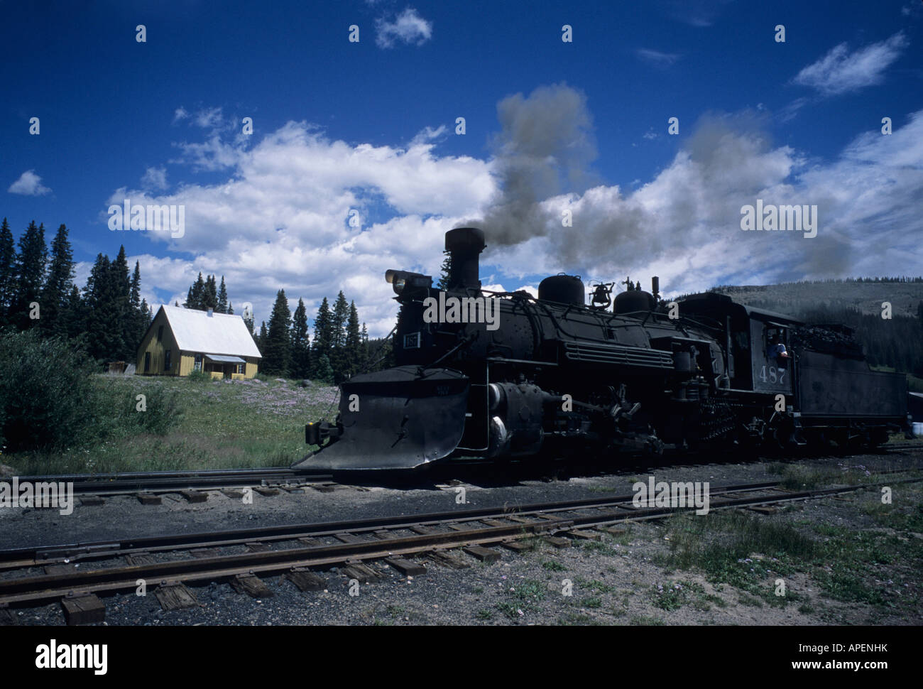 A steam engine passes through a station in the mountains Stock Photo ...