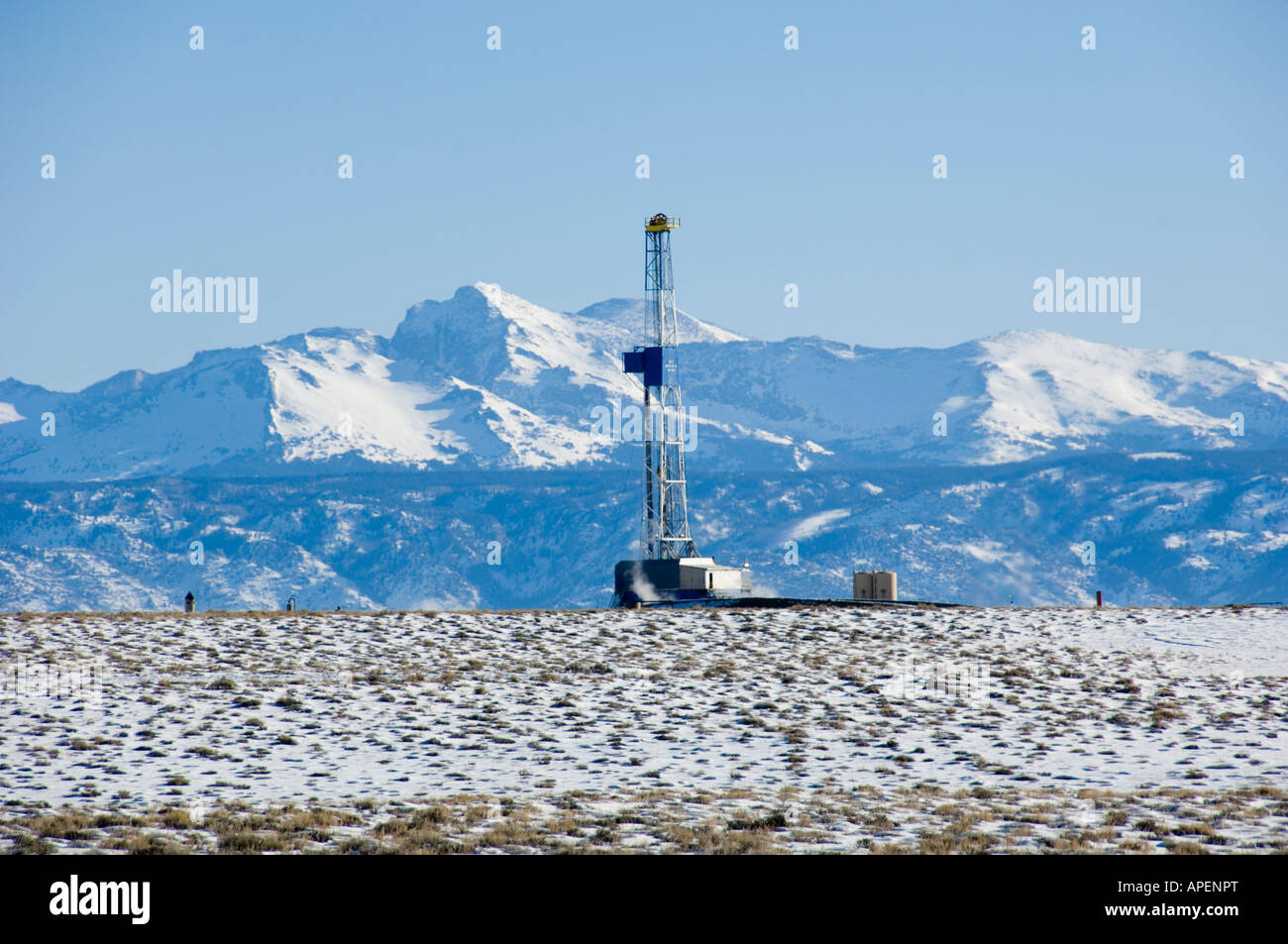 Drilling derrick near snow capped mountains in Wyoming Stock Photo - Alamy