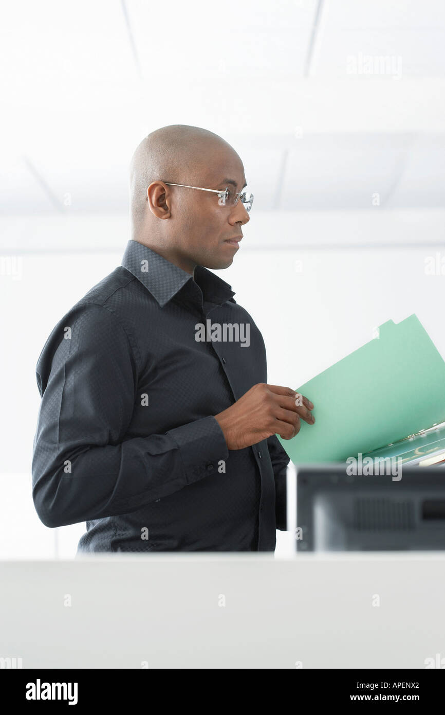 Office worker reading file in office, side view Stock Photo - Alamy
