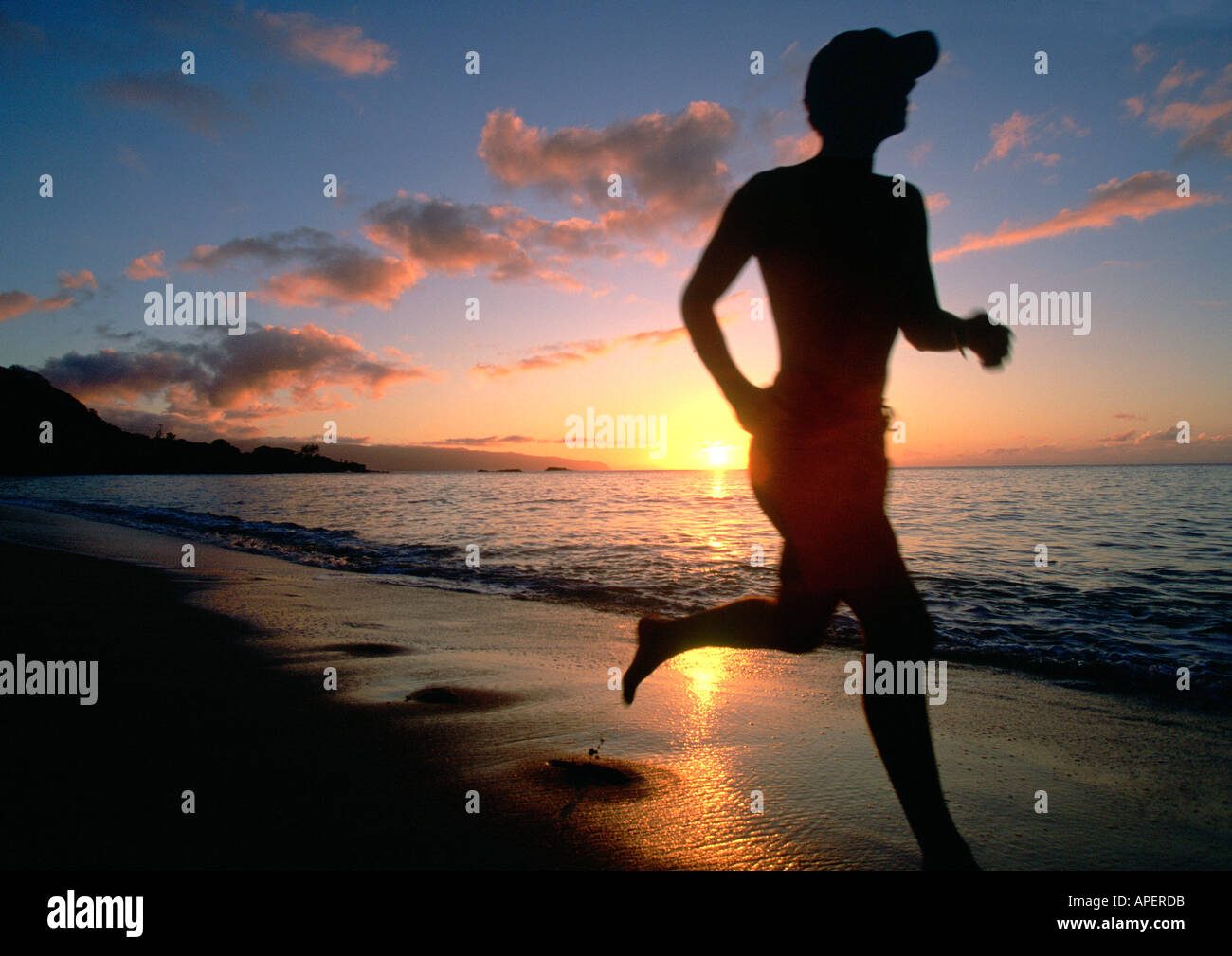 Man running on beach at sunset, Gabe Davies Stock Photo - Alamy