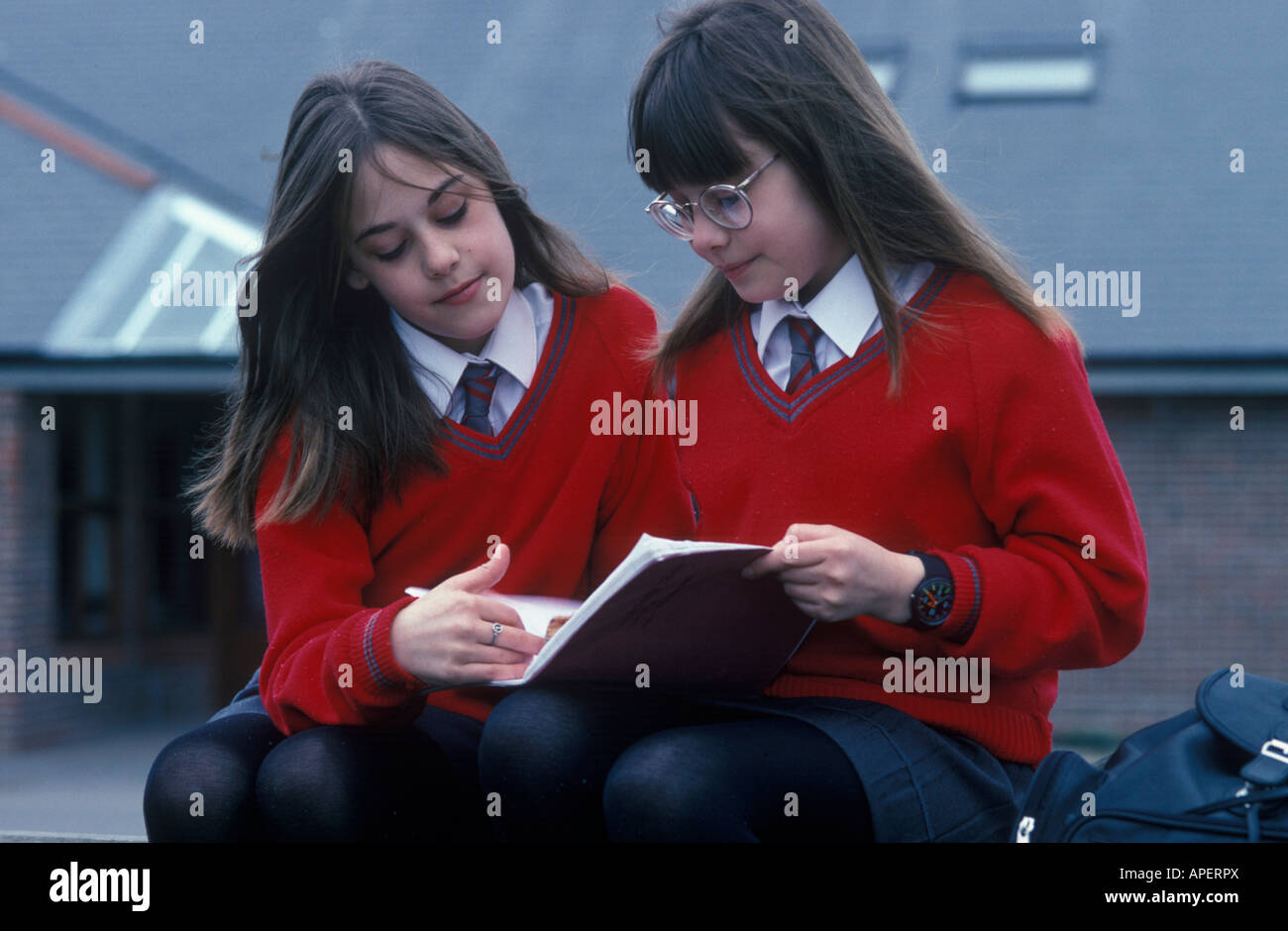 school girls sitting together and reading a book Stock Photo - Alamy