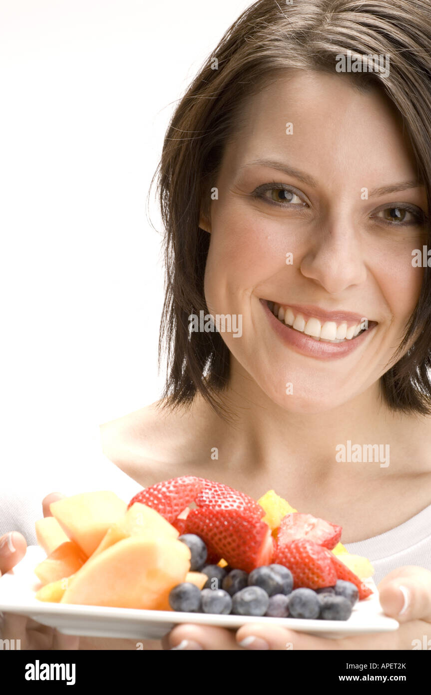 Young woman holding up plate of fresh fruits, healthy lifestyle Stock ...
