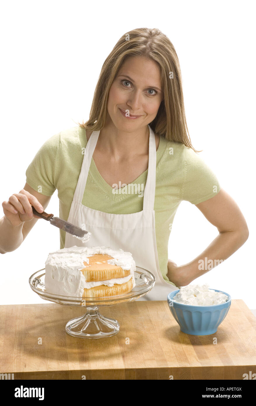 Studio shot of woman icing a cake Stock Photo - Alamy