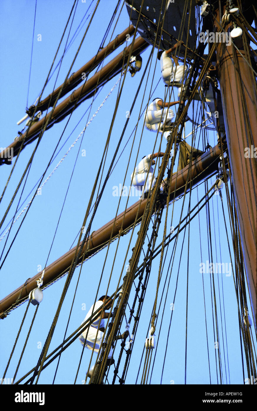 Sailors (Spanish) climbing rigging on large ship, blue sky Stock Photo ...