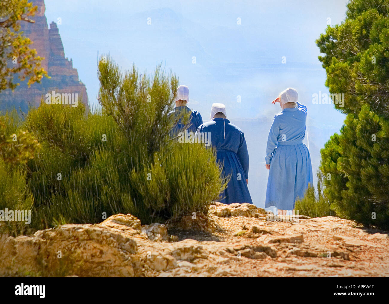 Amish girls in traditional blue dress and white hats overlooking the ...