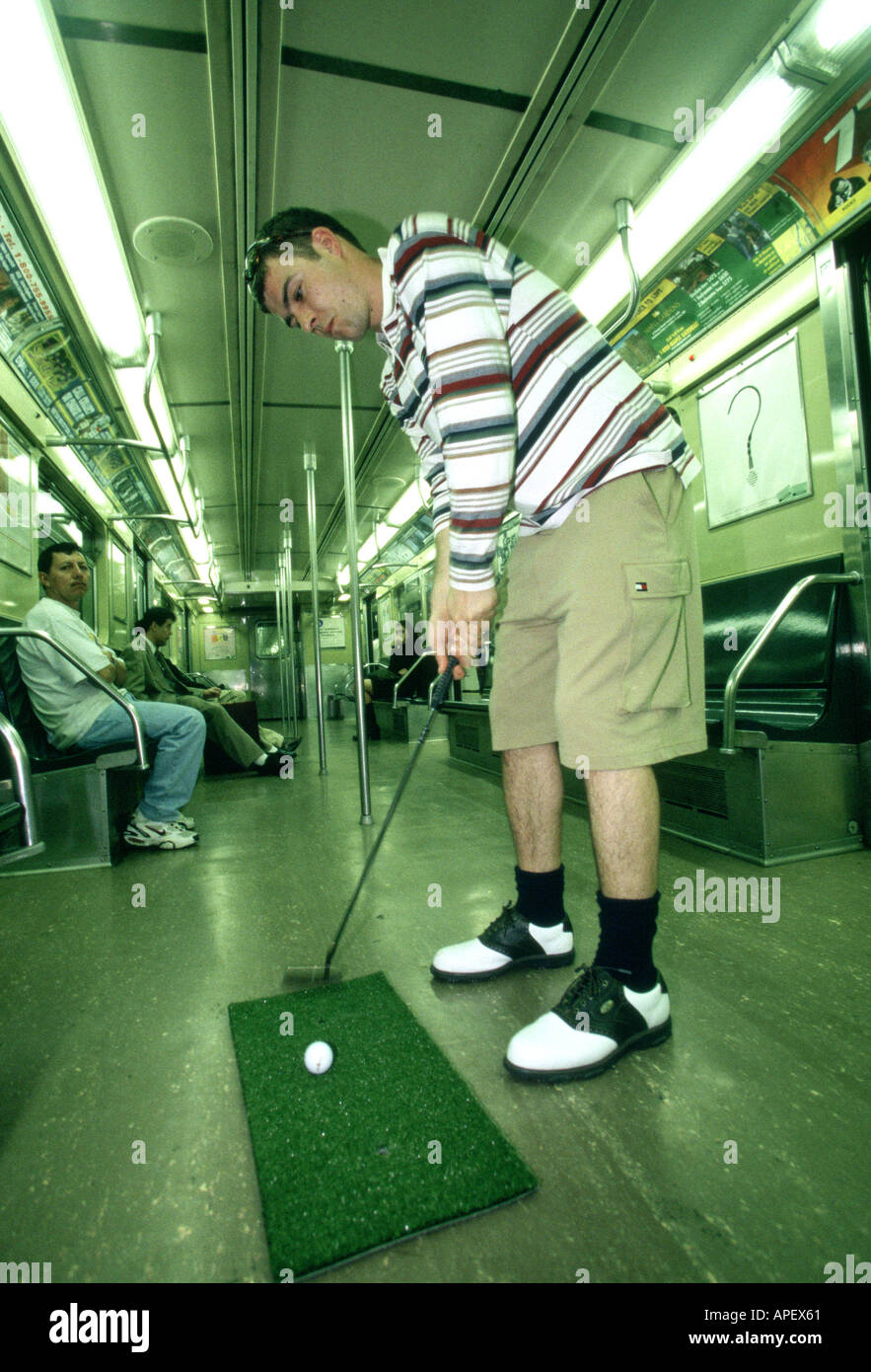Golfer putting on turf in subway train Stock Photo - Alamy
