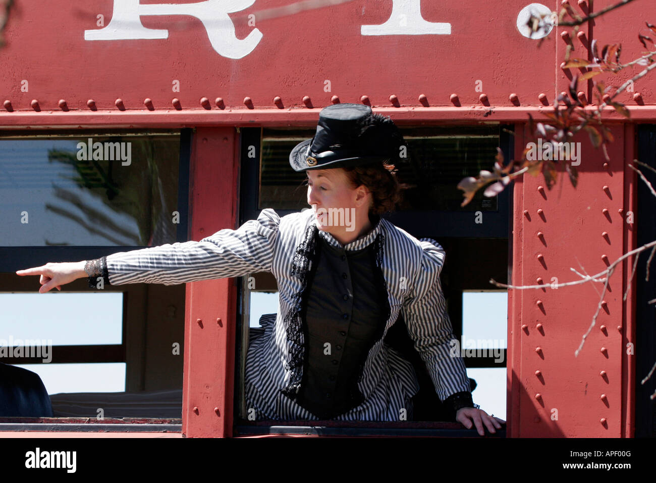 A classy and proper lady pointing out the window of a train at someone ...