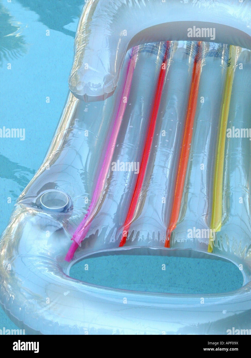 Colorful inflatable pool raft, colorful stripes, blue pool background ...