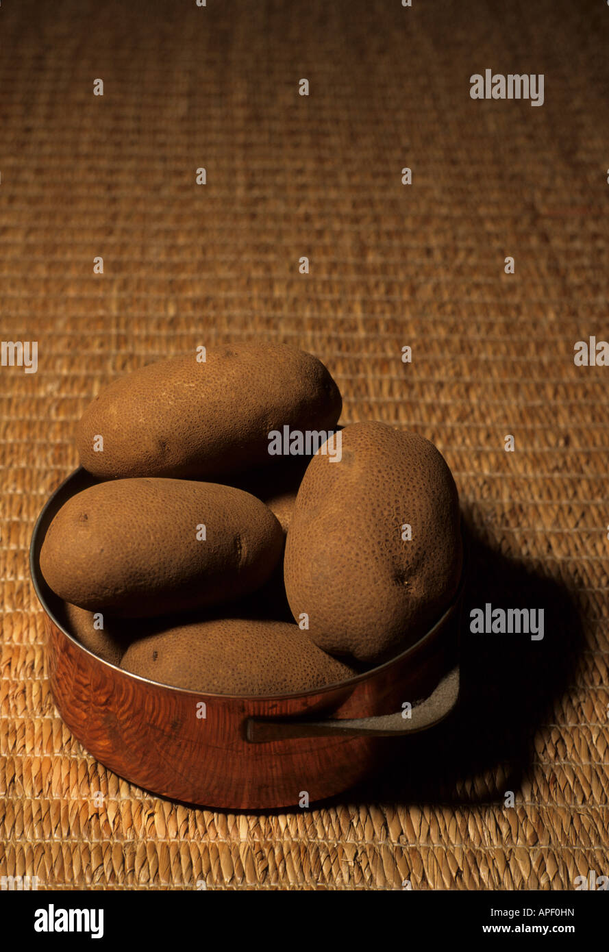 A group of baking potatoes sit in a brass cooking pot Stock Photo - Alamy