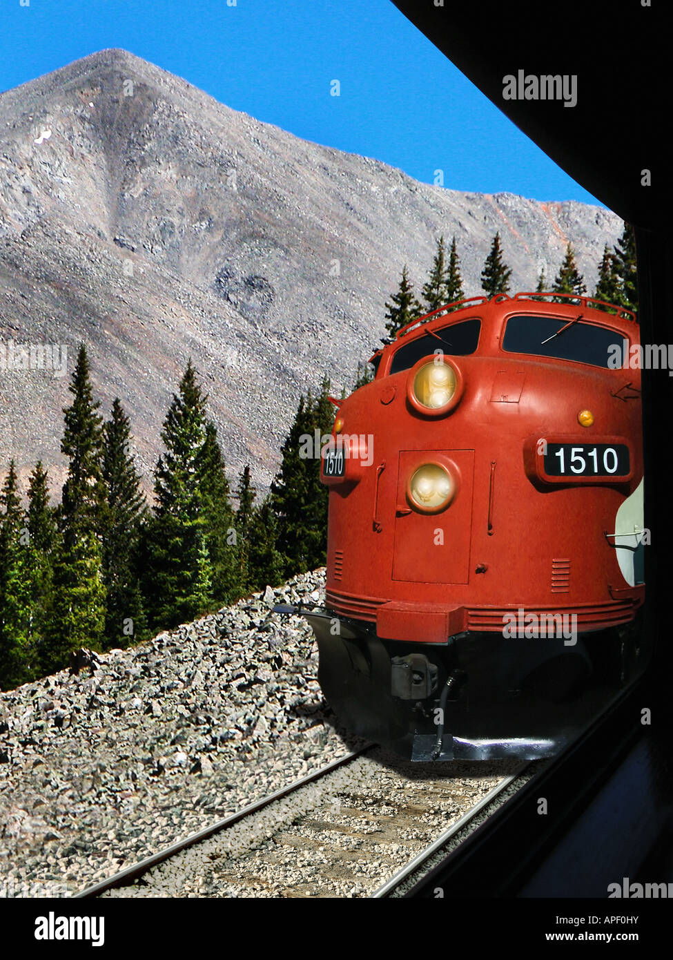 Locomotive front, red, with basalt / rock mountains and green pine ...