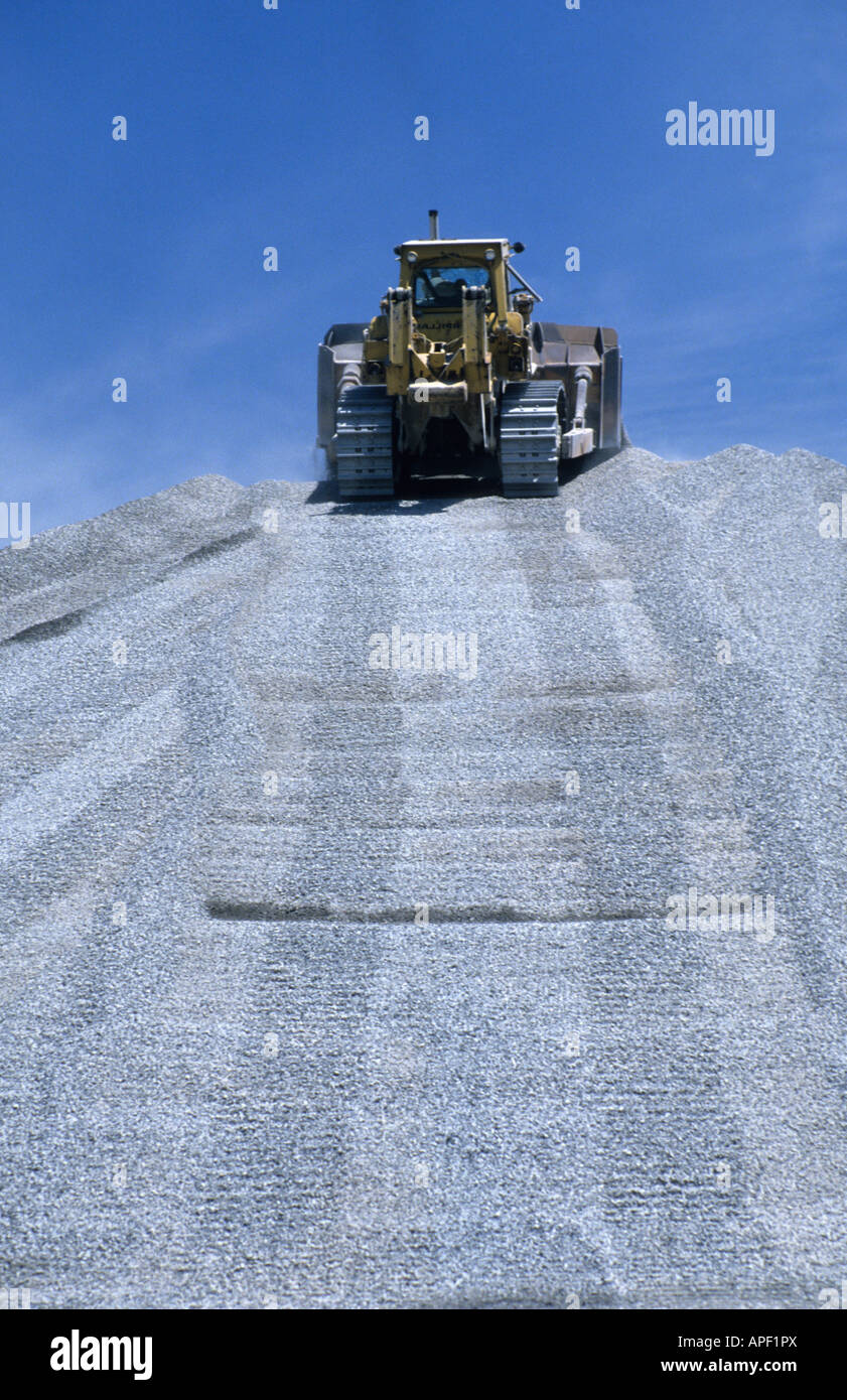 The bulldozer a powerful diesel machine is piling heaps of aggregate at ...