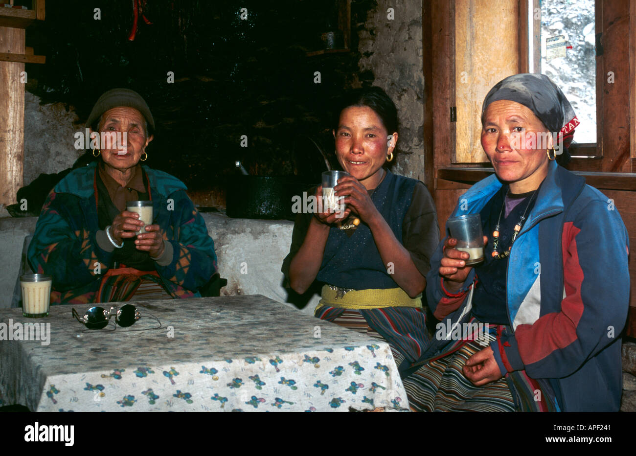 nepali women drinking chang fermented millet in their tea house kitchen ...