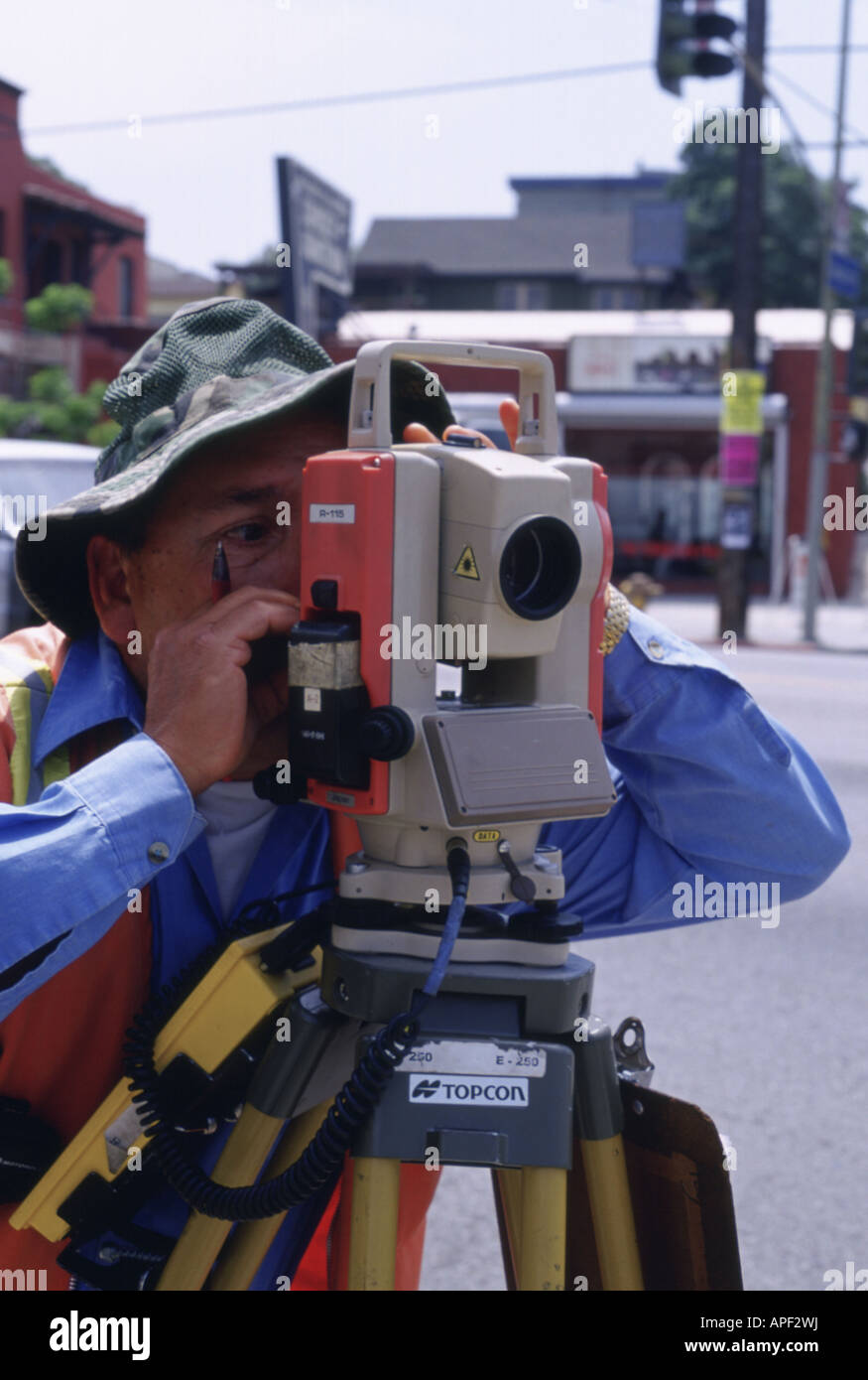 Worker using Electronic Distance Measuring machine for street ...